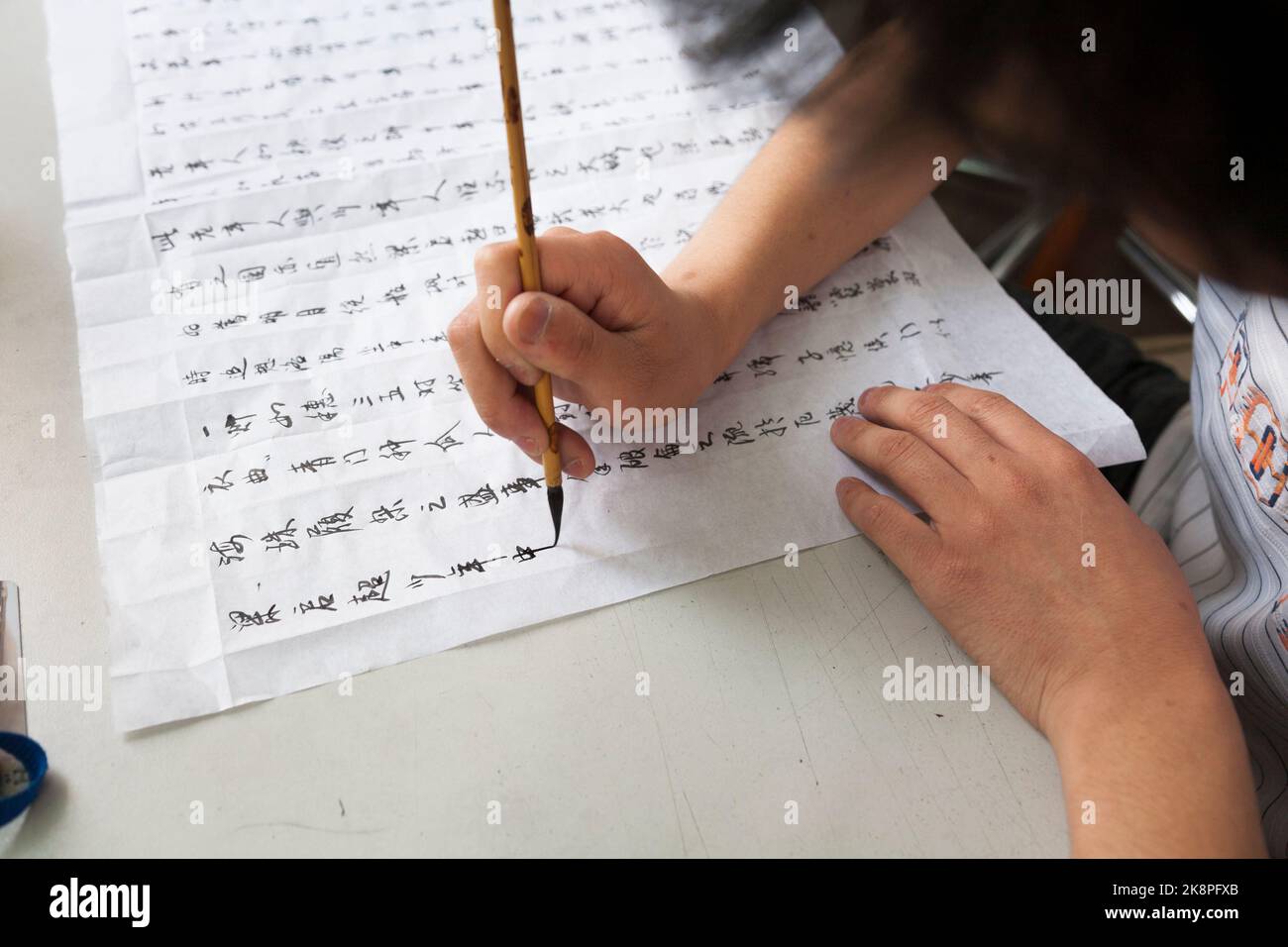 Chinese writing handwritten in vertical lines on a sheet of folded ...
