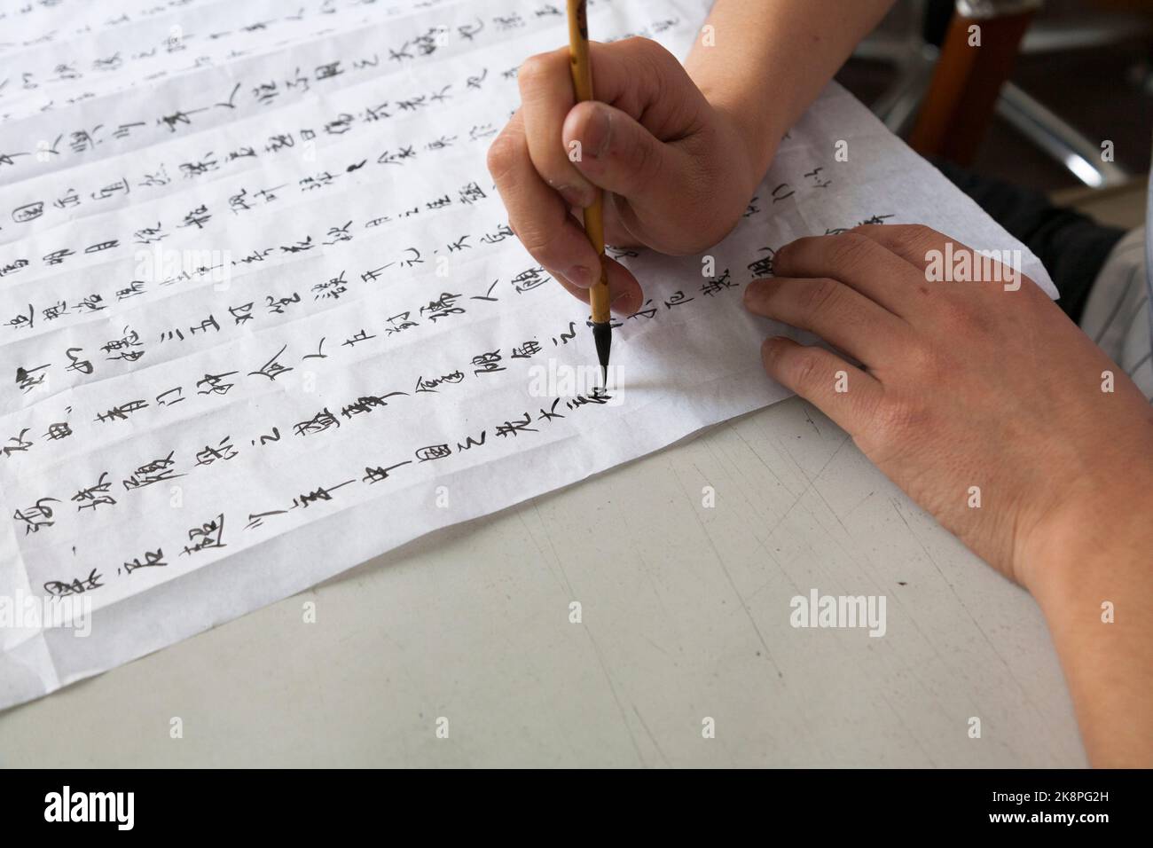 Chinese writing handwritten in vertical lines on a sheet of folded ...