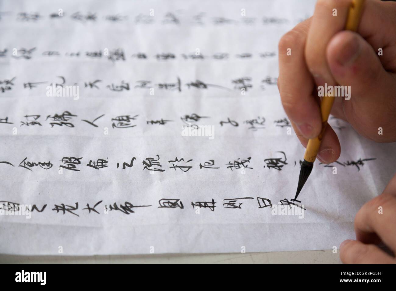 Chinese writing handwritten in vertical lines on a sheet of folded ...