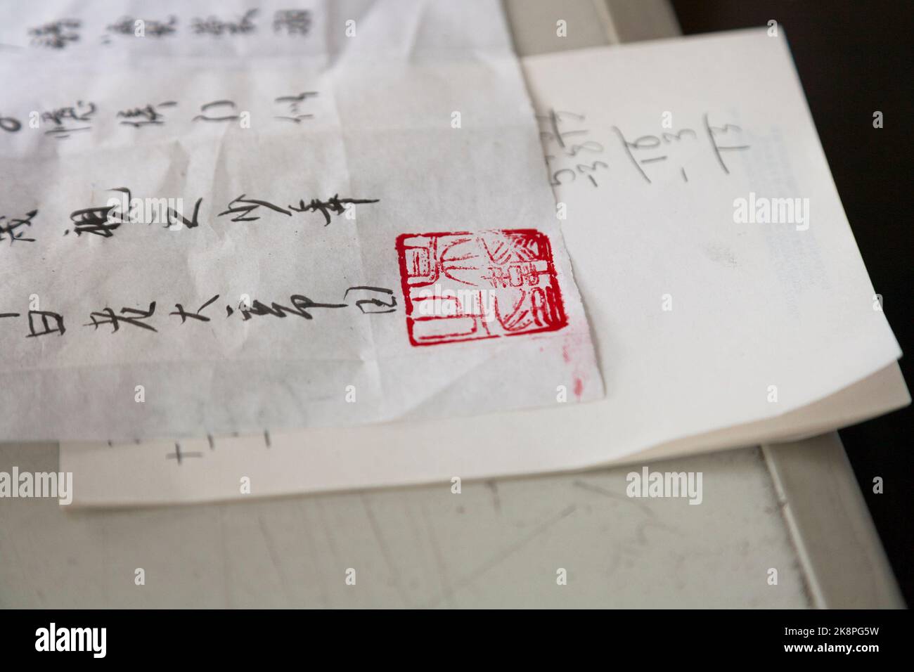 Chinese writing handwritten in vertical lines on a sheet of folded ...