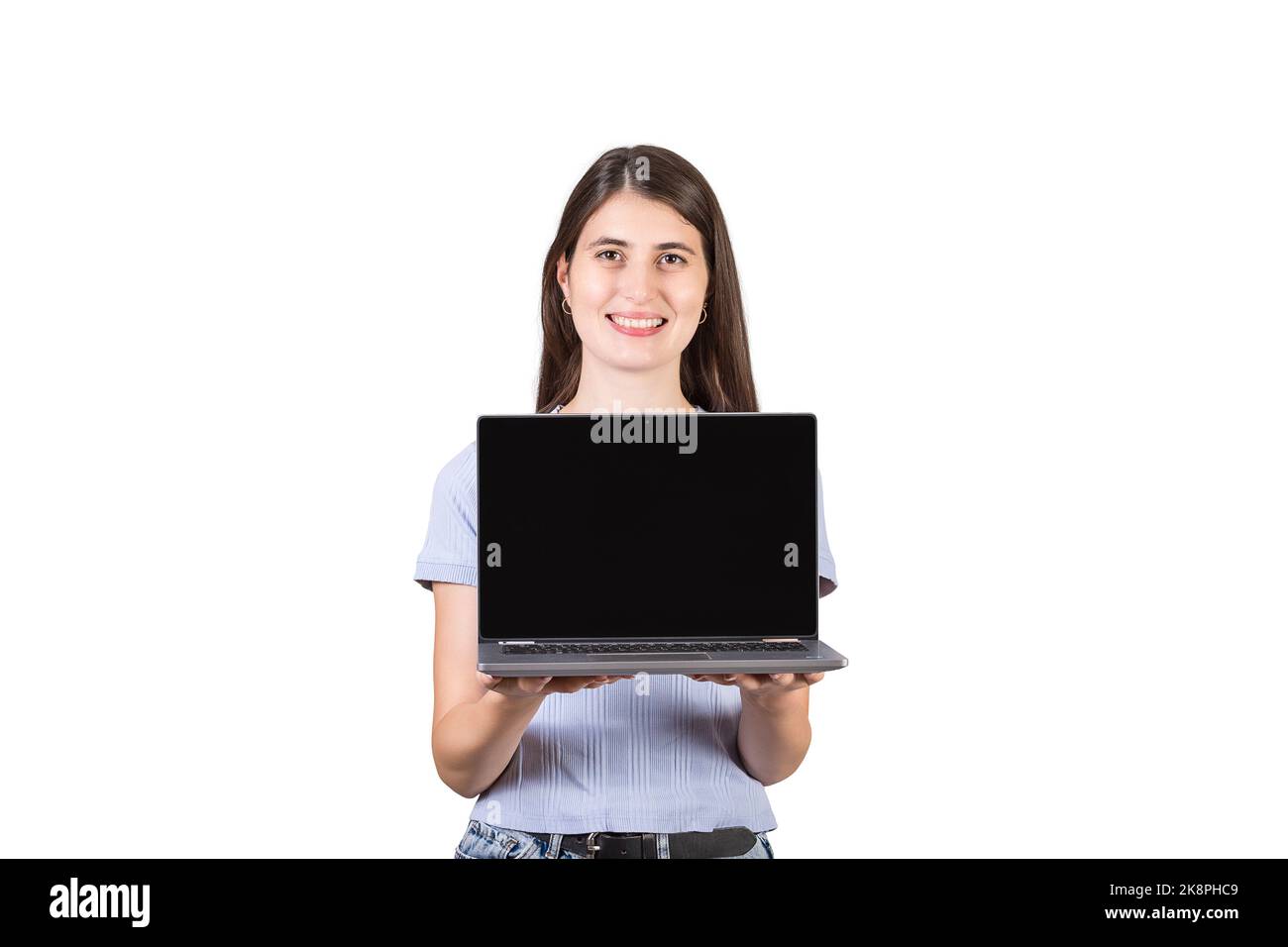 Cheerful young woman holding a laptop in her hands showing the blank ...
