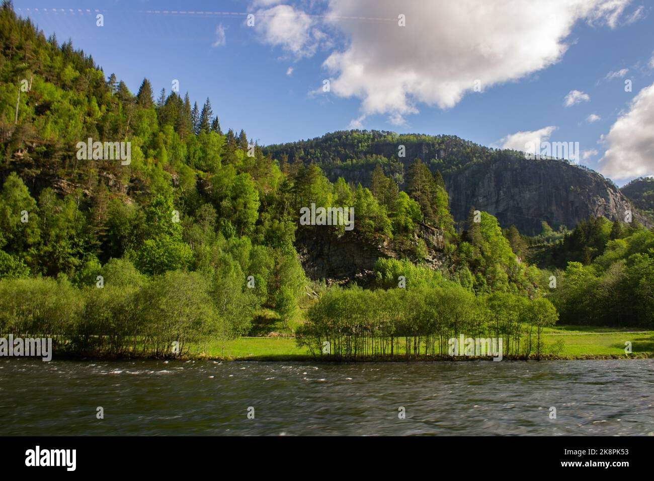 A scenic view of a river and green mountain forests at Narrow Fjord in ...