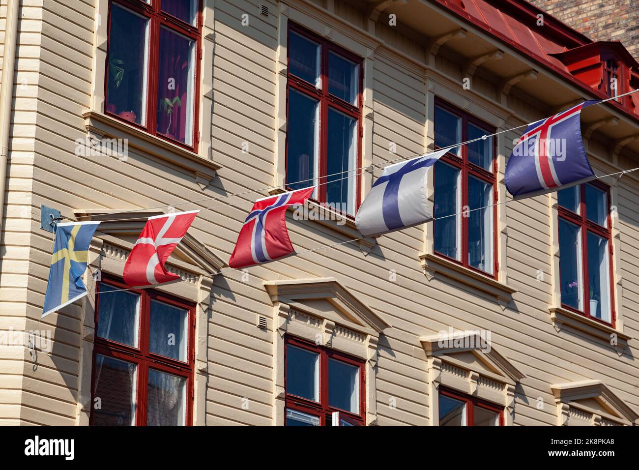 A row of Scandinavian flags hanging on a historic building in downtown ...