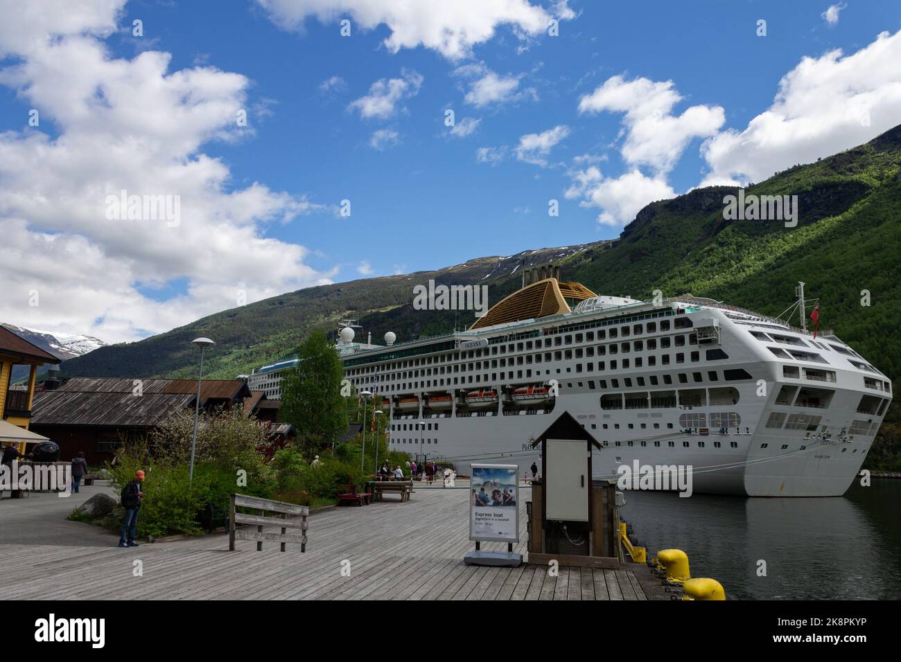 A port in a Flam town with a cruise ship sailing on Narrow Fjord ...