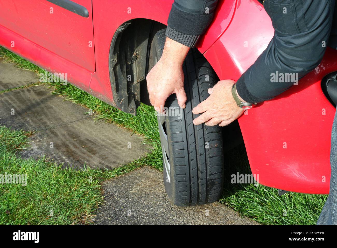 Checking tyre tread on a vehicle by feeling the depth Stock Photo - Alamy