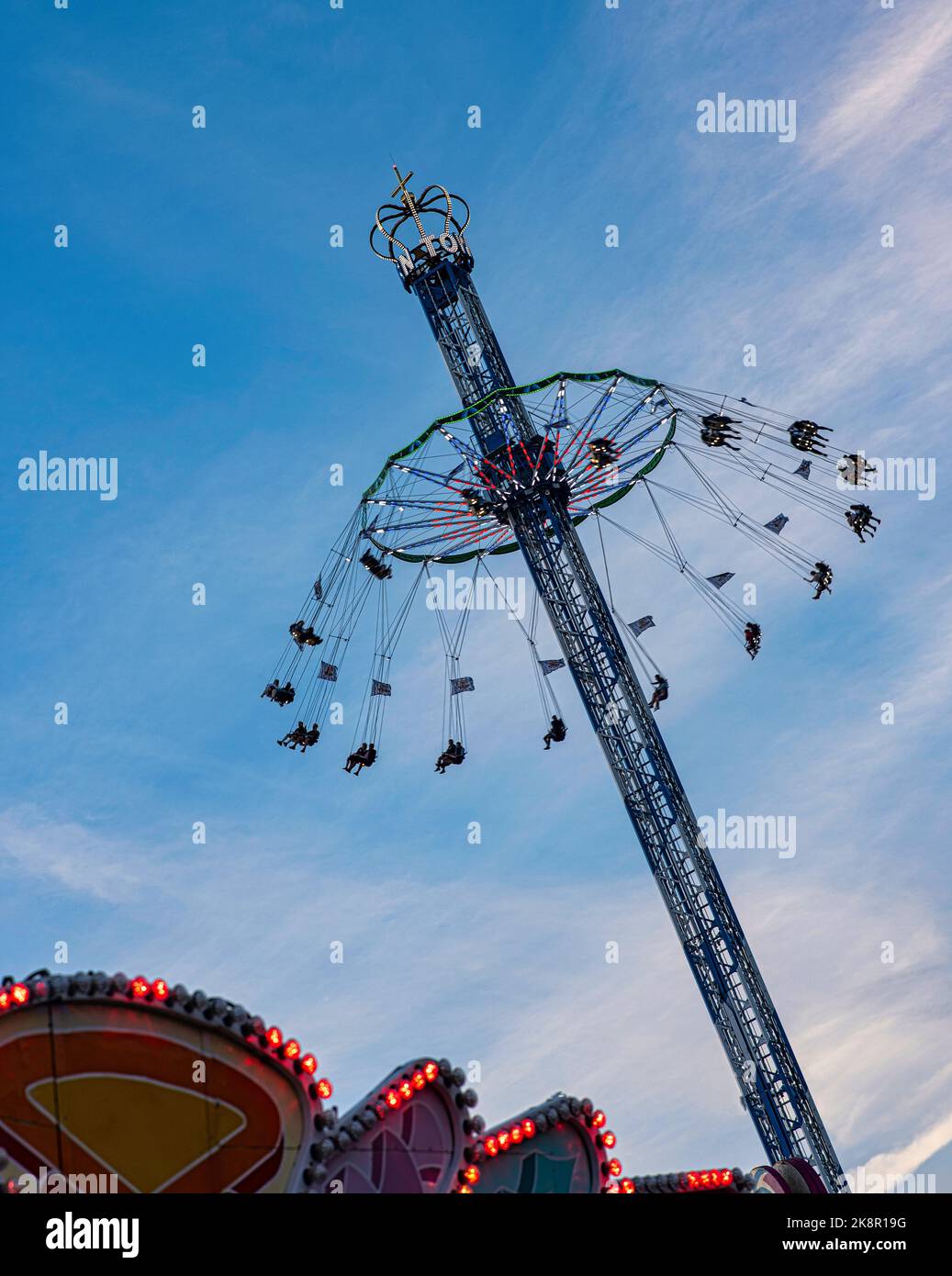 Vertical shot of a carousel at Munichs famous Oktoberfest with blue sky ...