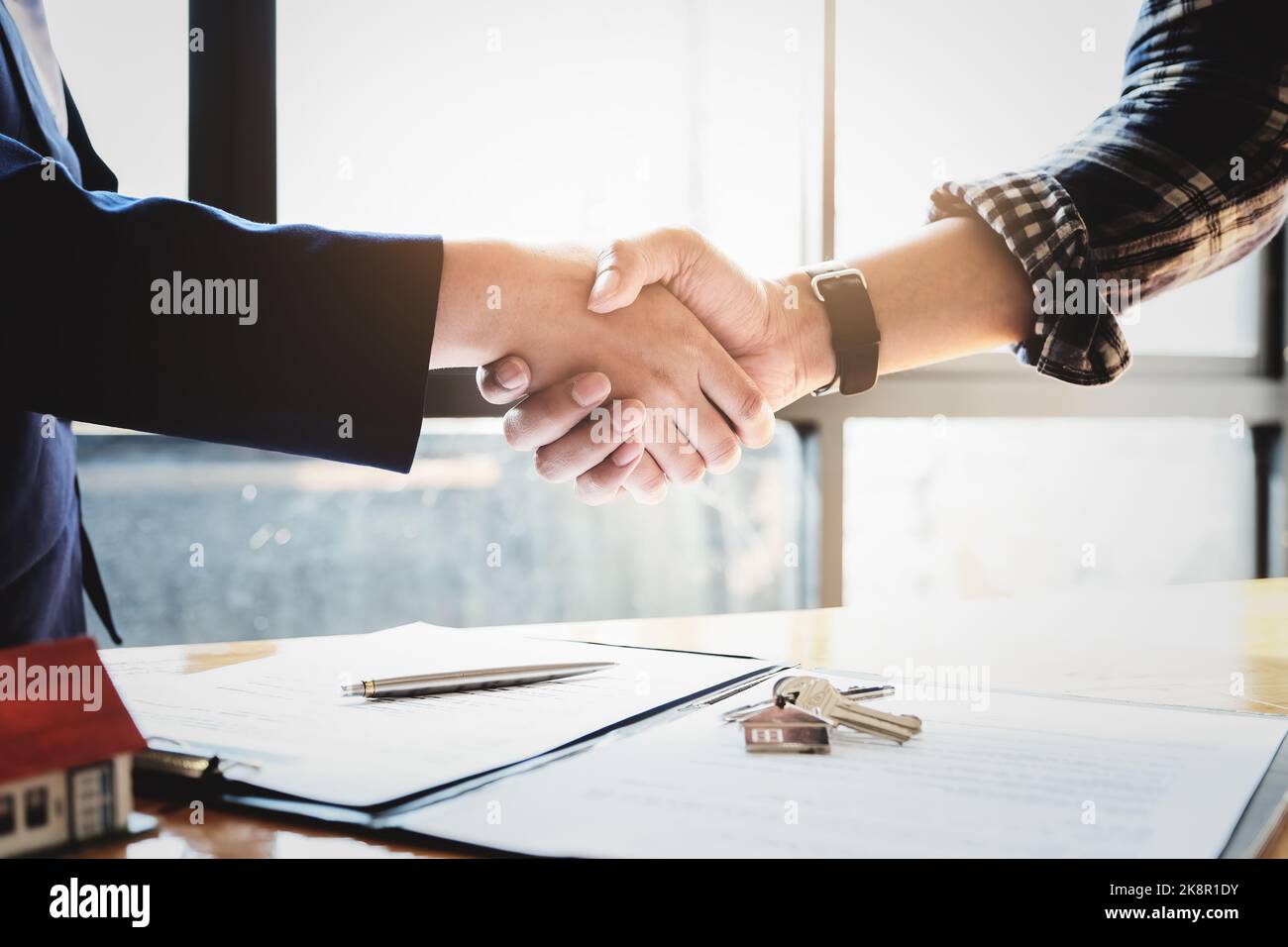 Focus on the congratulatory handshake. The real estate agent agrees to ...