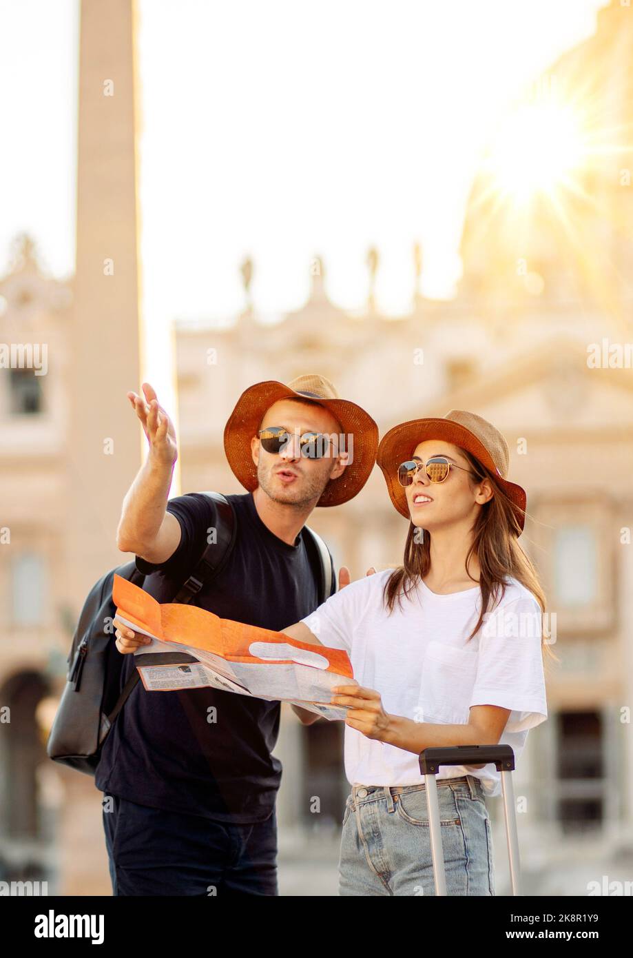 Happy tourists looking at a map and choose a hotel. Couple of tourists ...