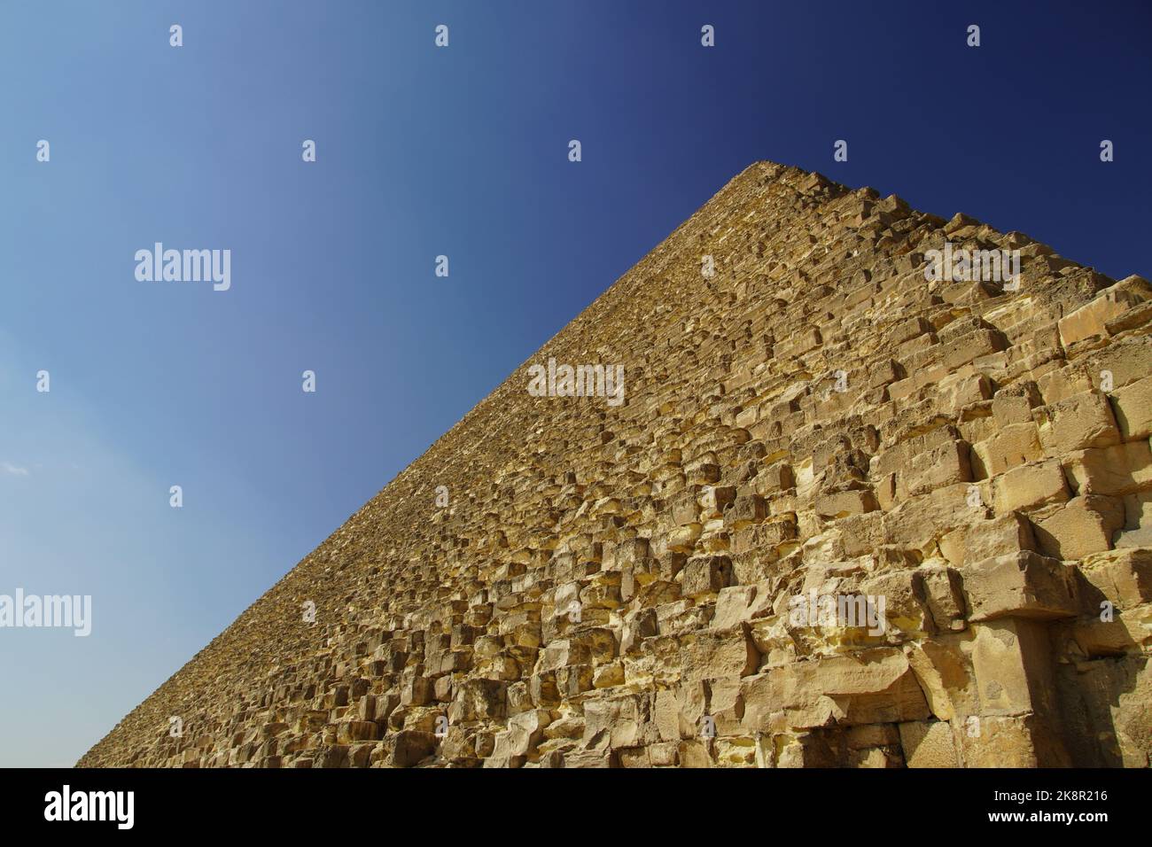 A low angle shot of the Great Pyramid of Giza against a sunny sky in ...