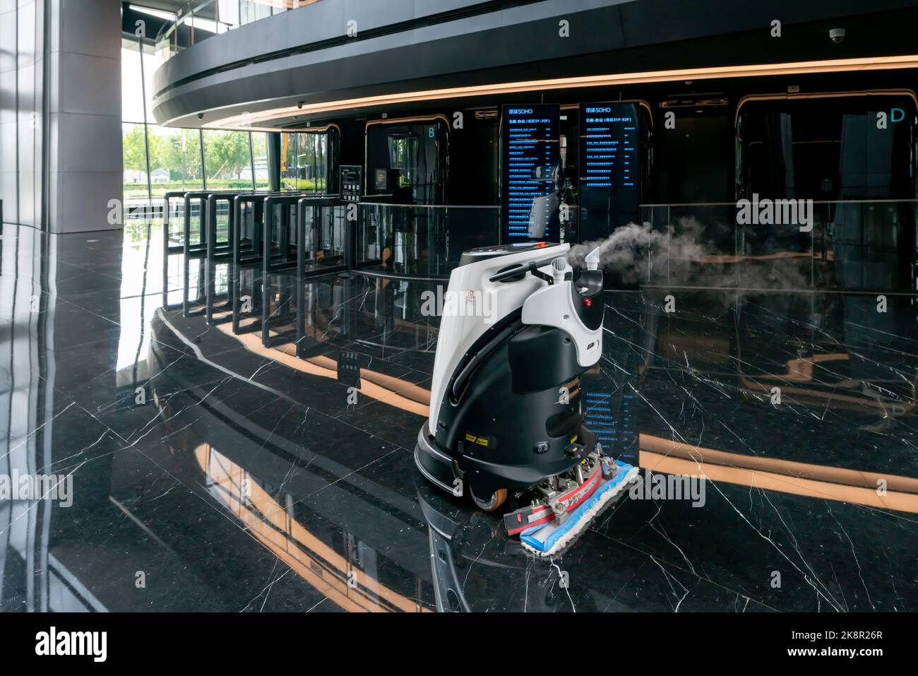 An automatic AI cleaner mopping floor inside of a modern office ...