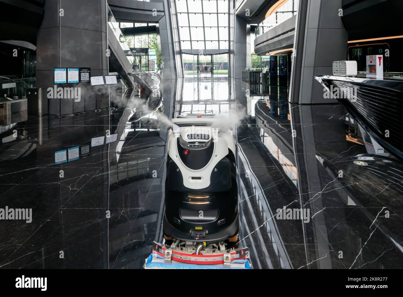 An automatic AI cleaner mopping floor inside of a modern office ...
