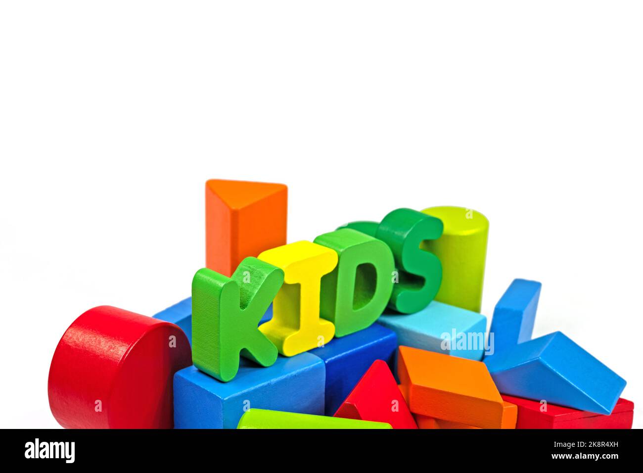 Wooden building blocks of different shapes and colors against a white ...