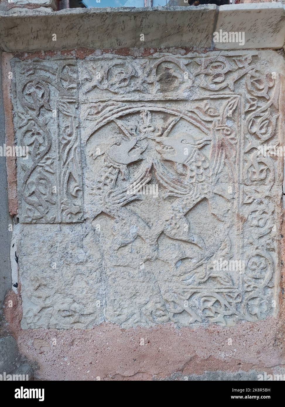 A closeup shot of an old carving of two animals facing each other on a ...