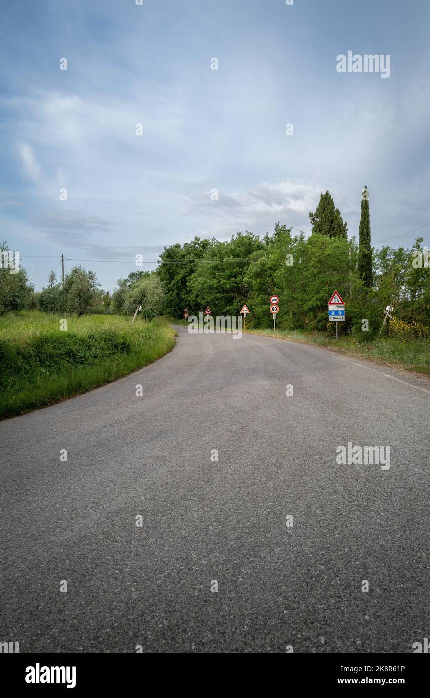 A vertical shot of a road with signs in nature in Certaldo Tuscany ...