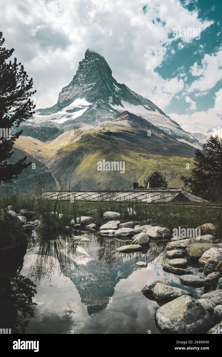 Portrait of the Matterhorn with a reflection of the mountain off a pond ...
