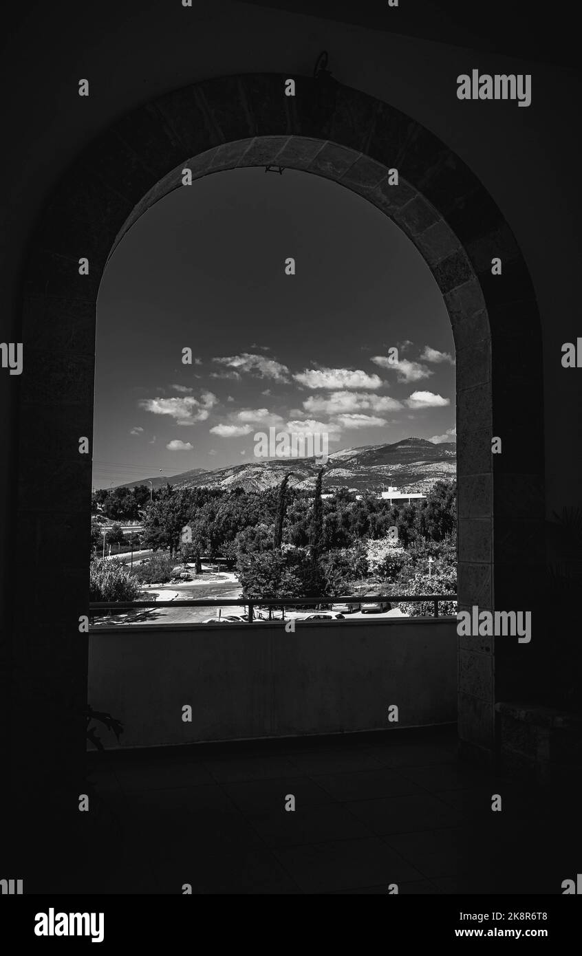 A beautiful scenery of nature out of an arched door of balcony in the ...