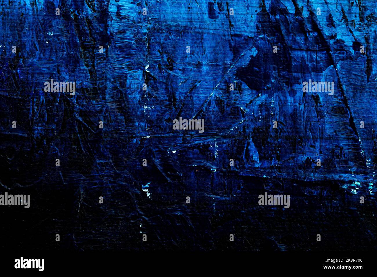 Macro close-up of an abstract black and blue acrylic paint background ...