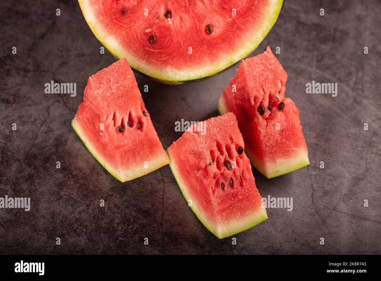 A top view of watermelon slices and halved watermelon on kitchen ...