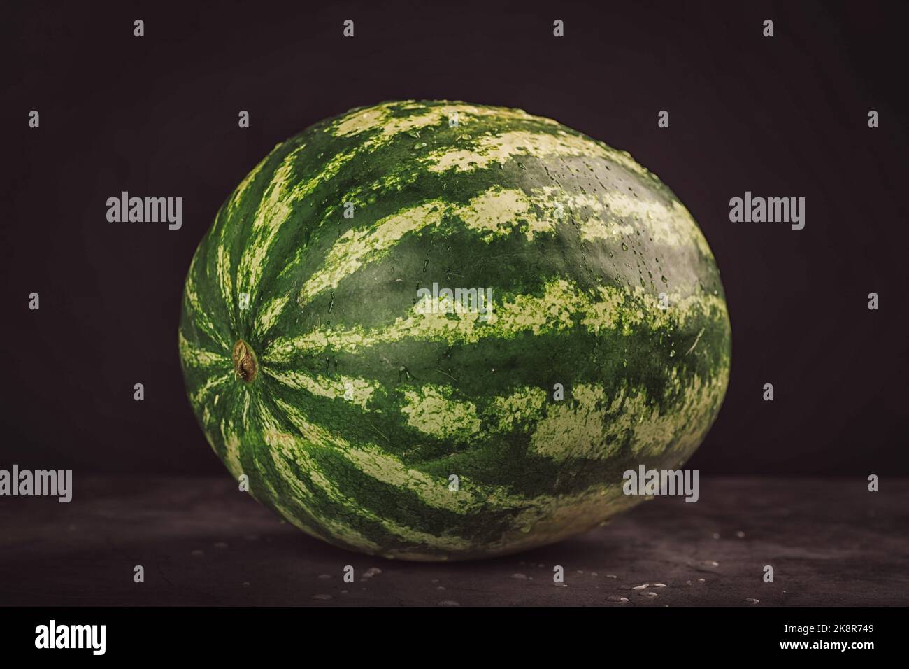 A closeup of whole wet round watermelon on blur wooden counter Stock ...