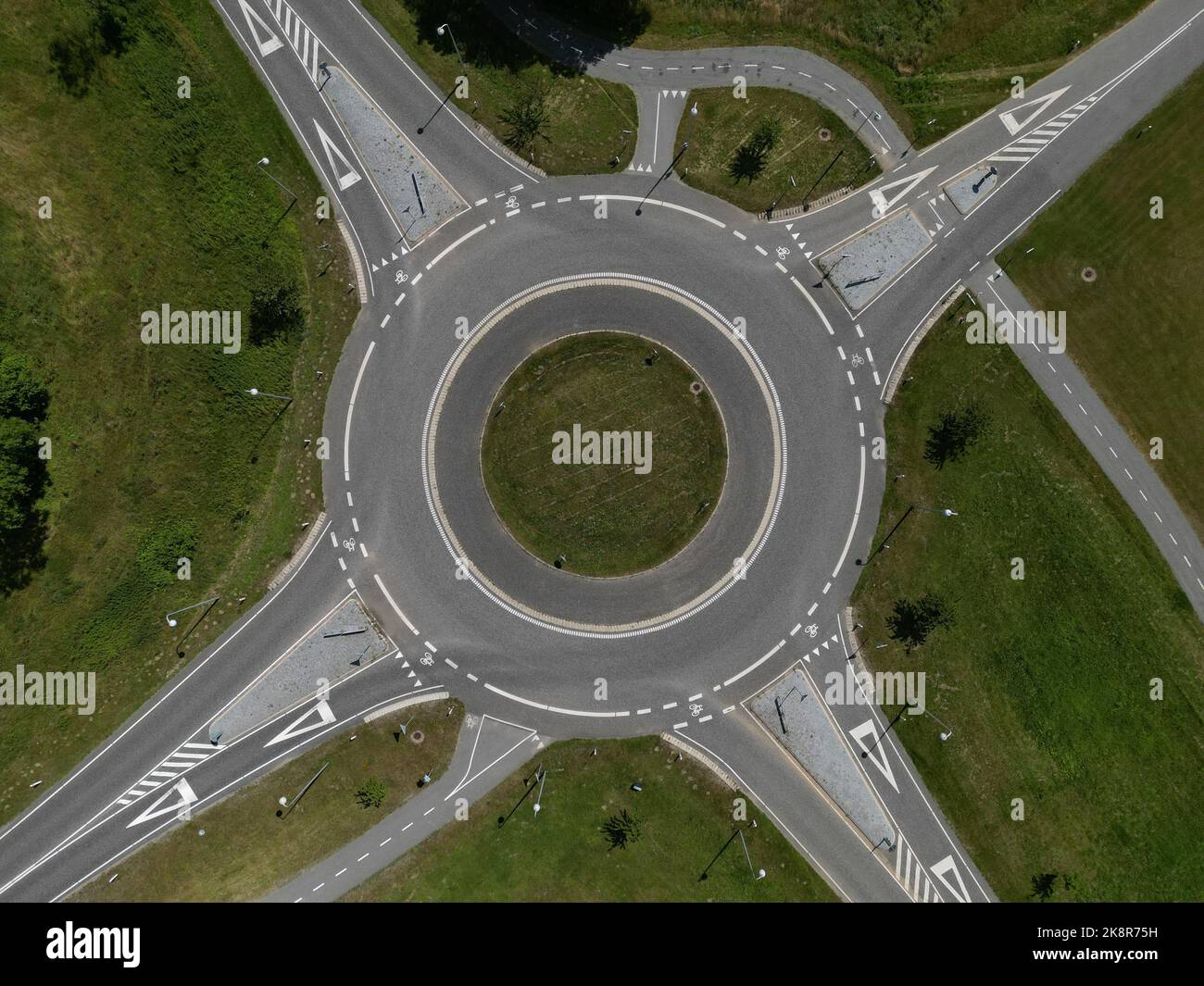 An aerial top view of the roads meeting in a round square with green ...