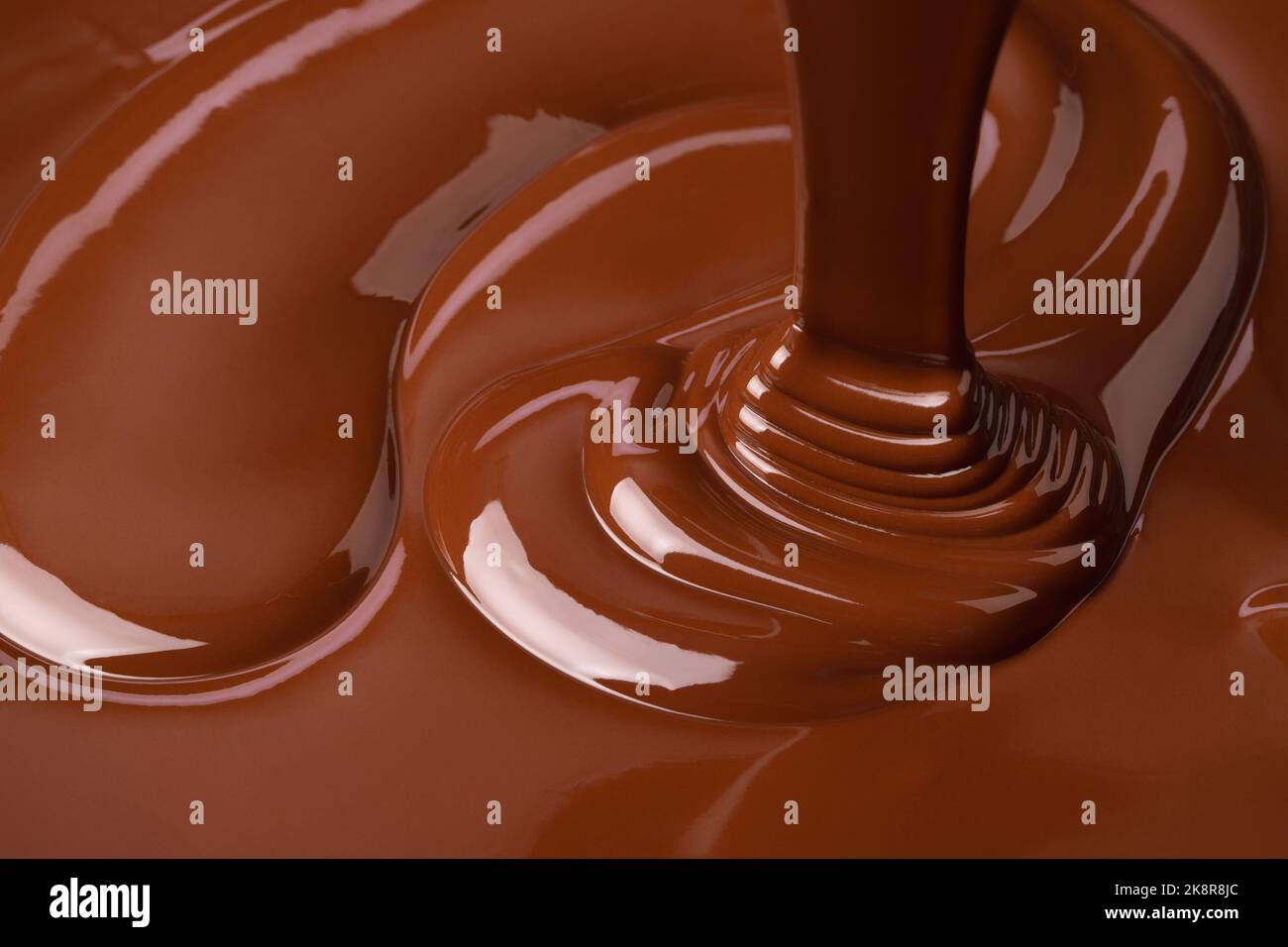 Ribbons hot chocolate pouring forming waves. stream of sweet syrup as ...