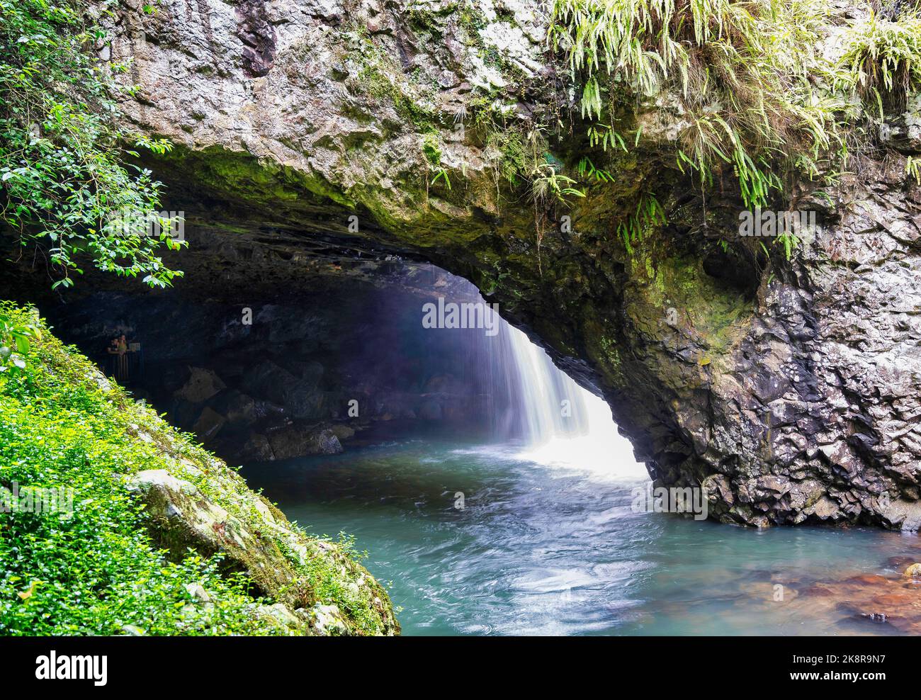 The Natural Bridge Falls with a cave and a waterfall in the background ...