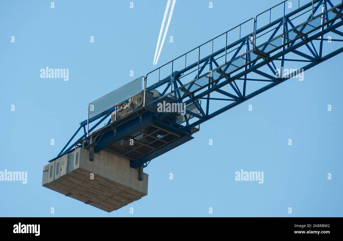 the boom of a tower crane on the background of an airplane flying in ...