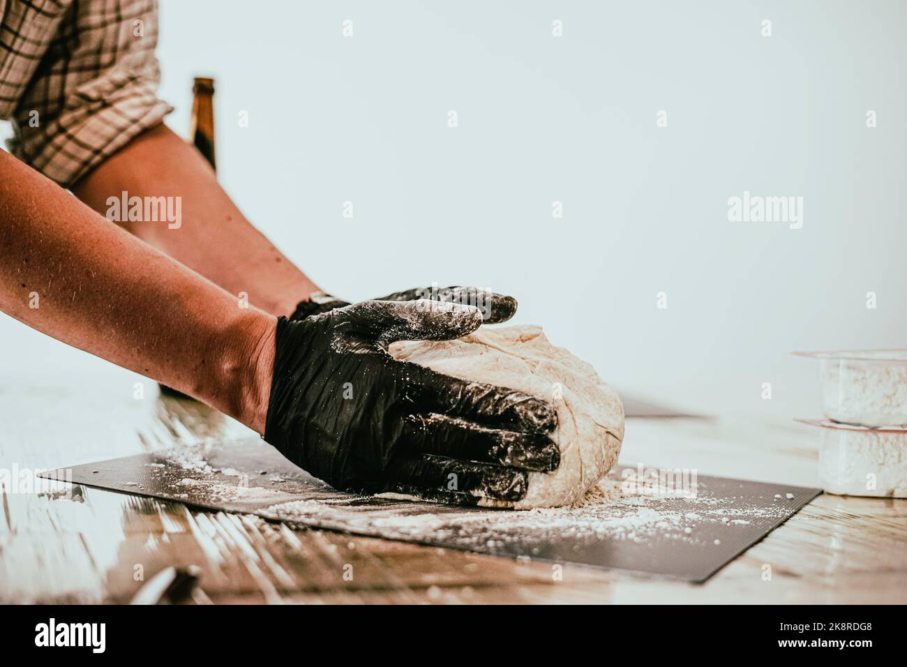 Man hands in black gloves preparing dough in a flour Stock Photo - Alamy
