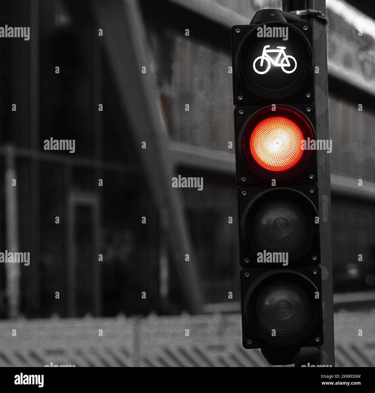 A squared closeup of a bike traffic light showing red light stop sign ...