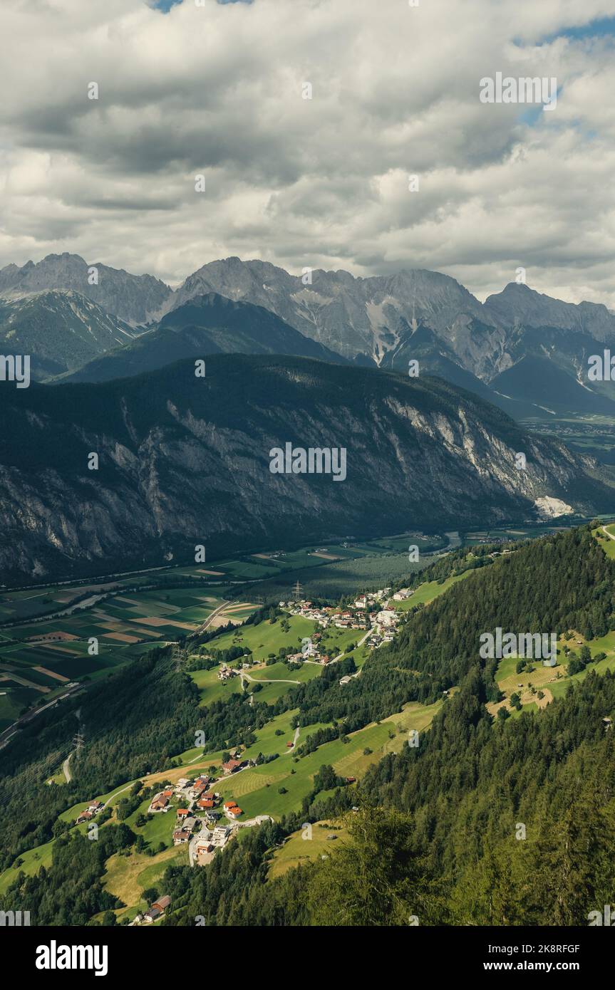 A vertical shot of a countryside with dense forests and high mountain ...