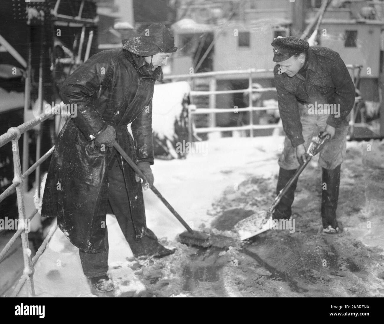 Working life on board the boat "Bali". Two men clear snow from the ship ...