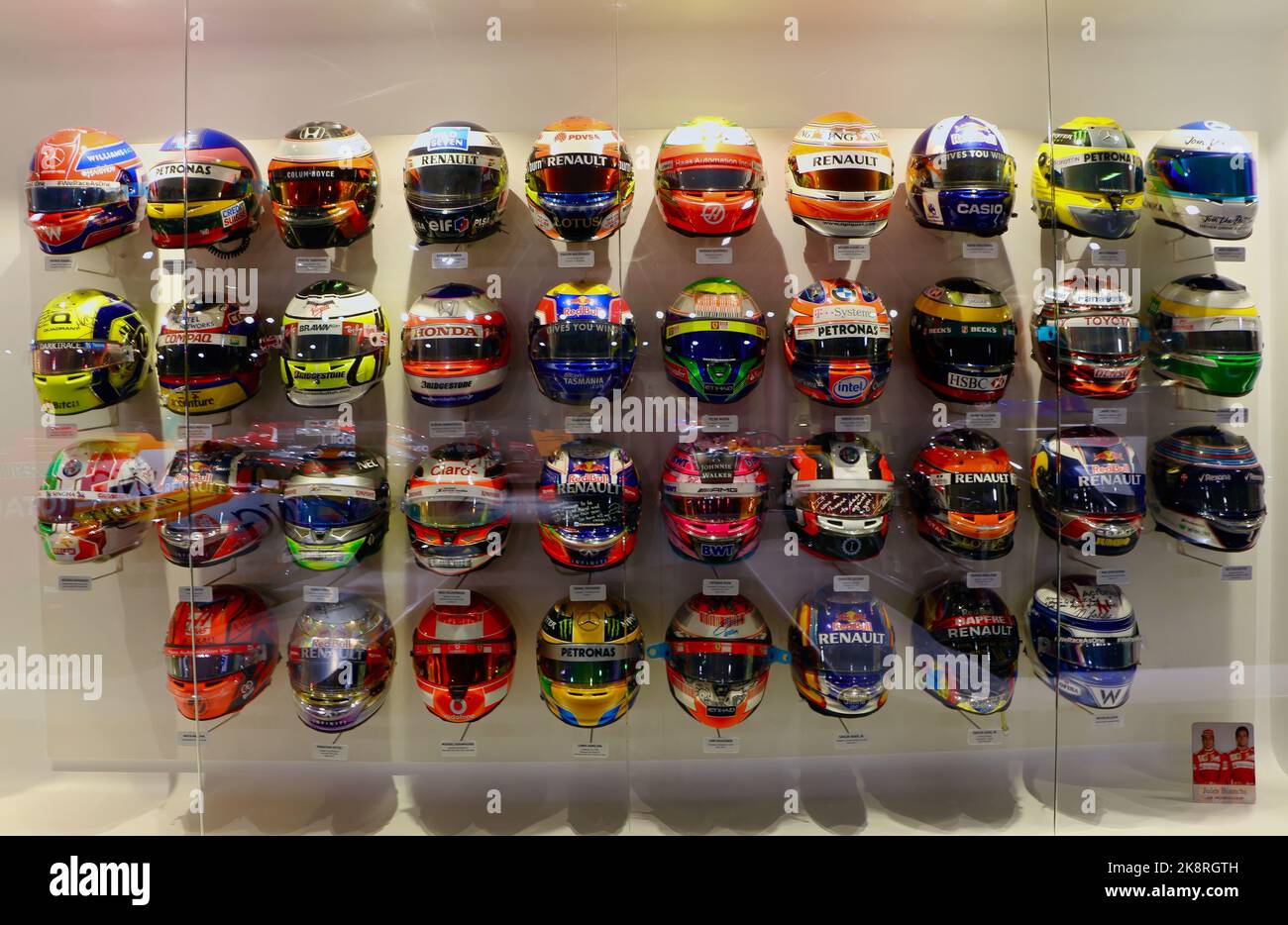 Wall mounted collection of gifted signed crash helmets from Formula 1 ...