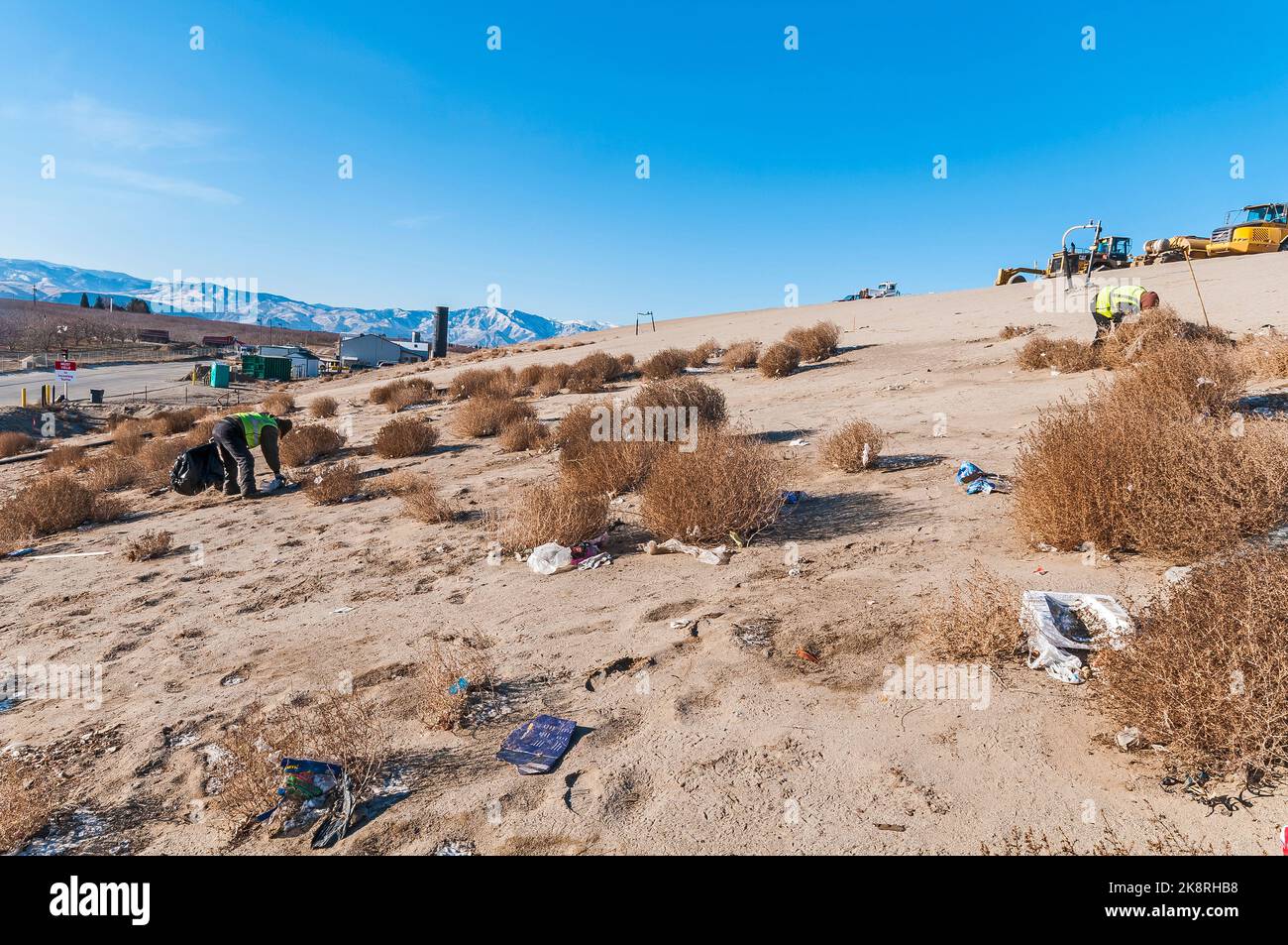 Workers at an active landfill with a processing station in the ...