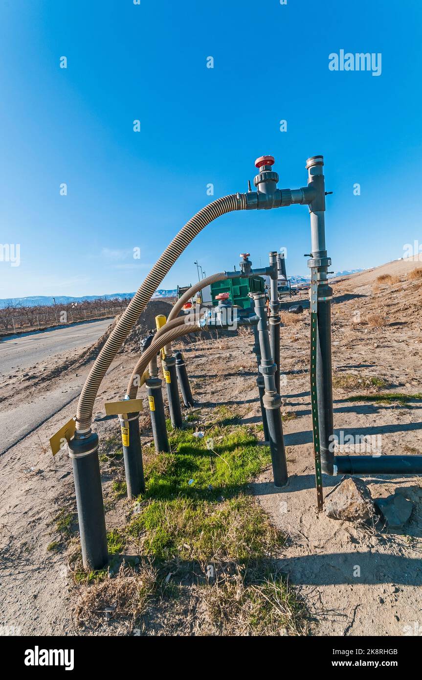 A vertical landfill methane gas wellhead at an active landfill frames ...