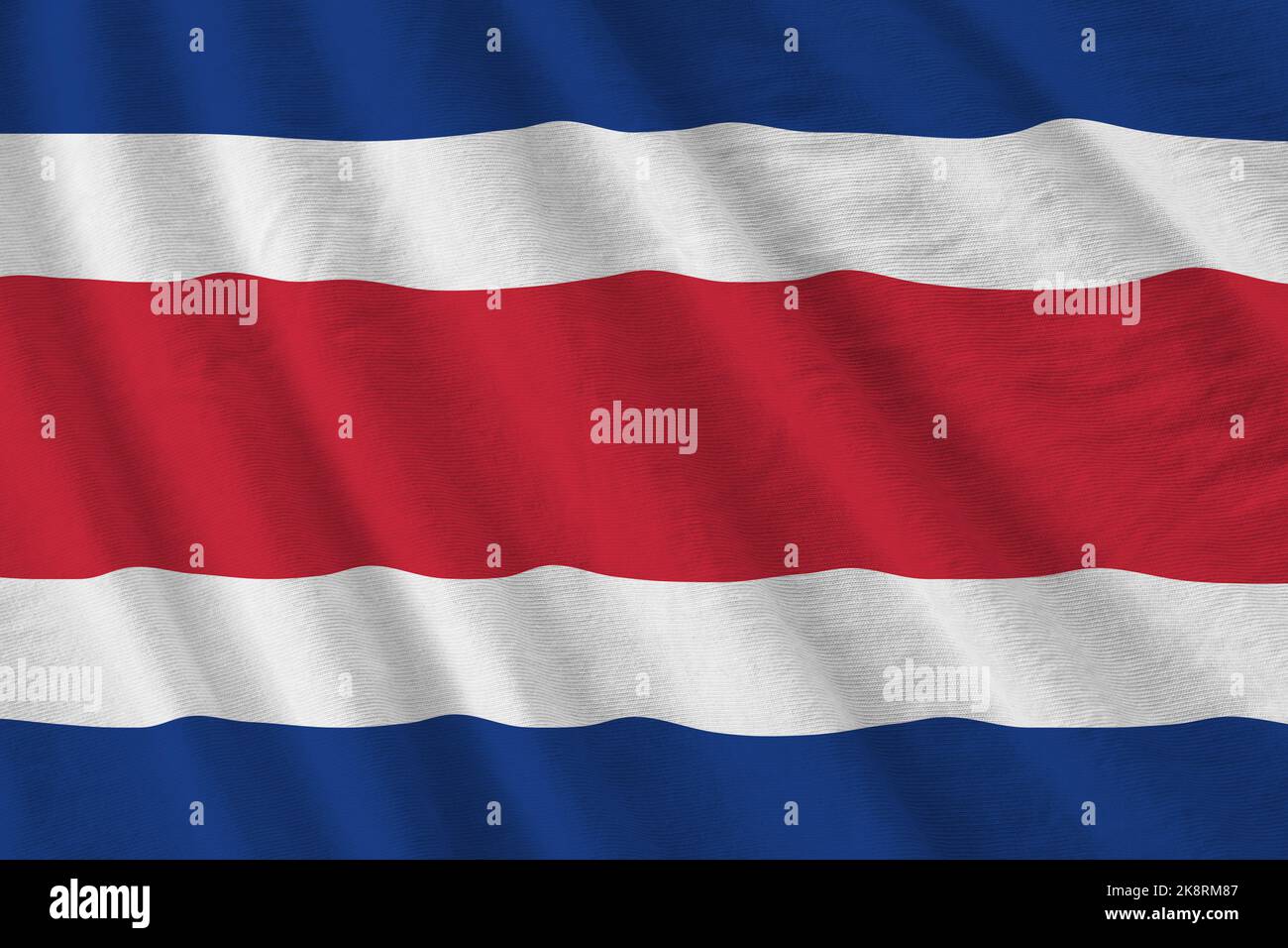 Costa Rica flag with big folds waving close up under the studio light ...