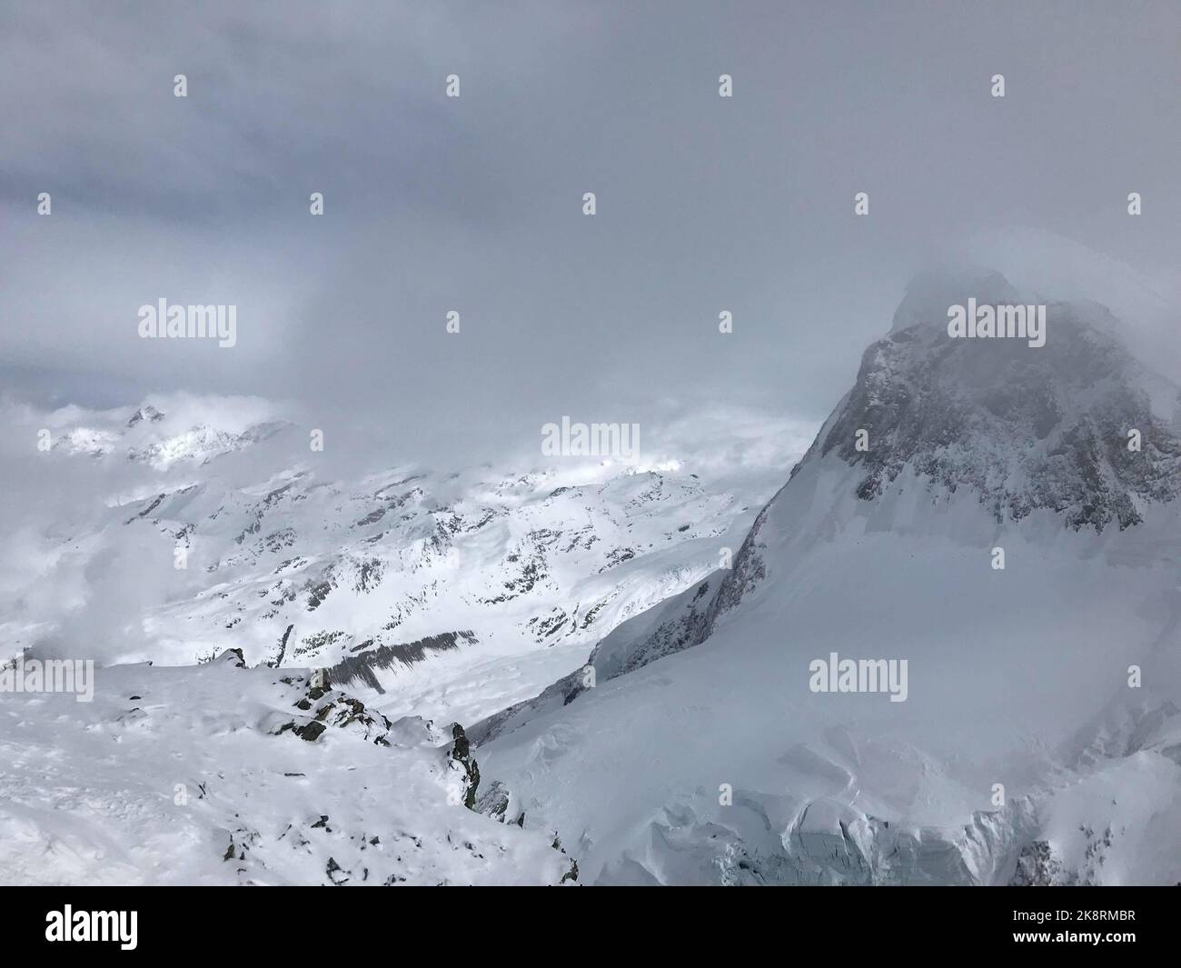 A range of high mountain peaks covered in snow in the mist Stock Photo ...