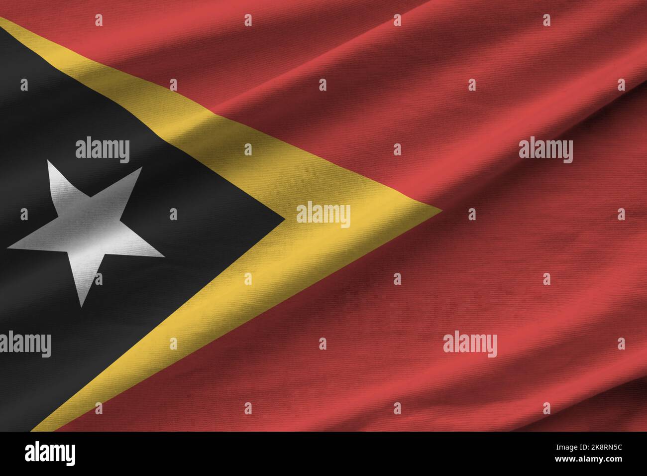 Timor Leste flag with big folds waving close up under the studio light ...