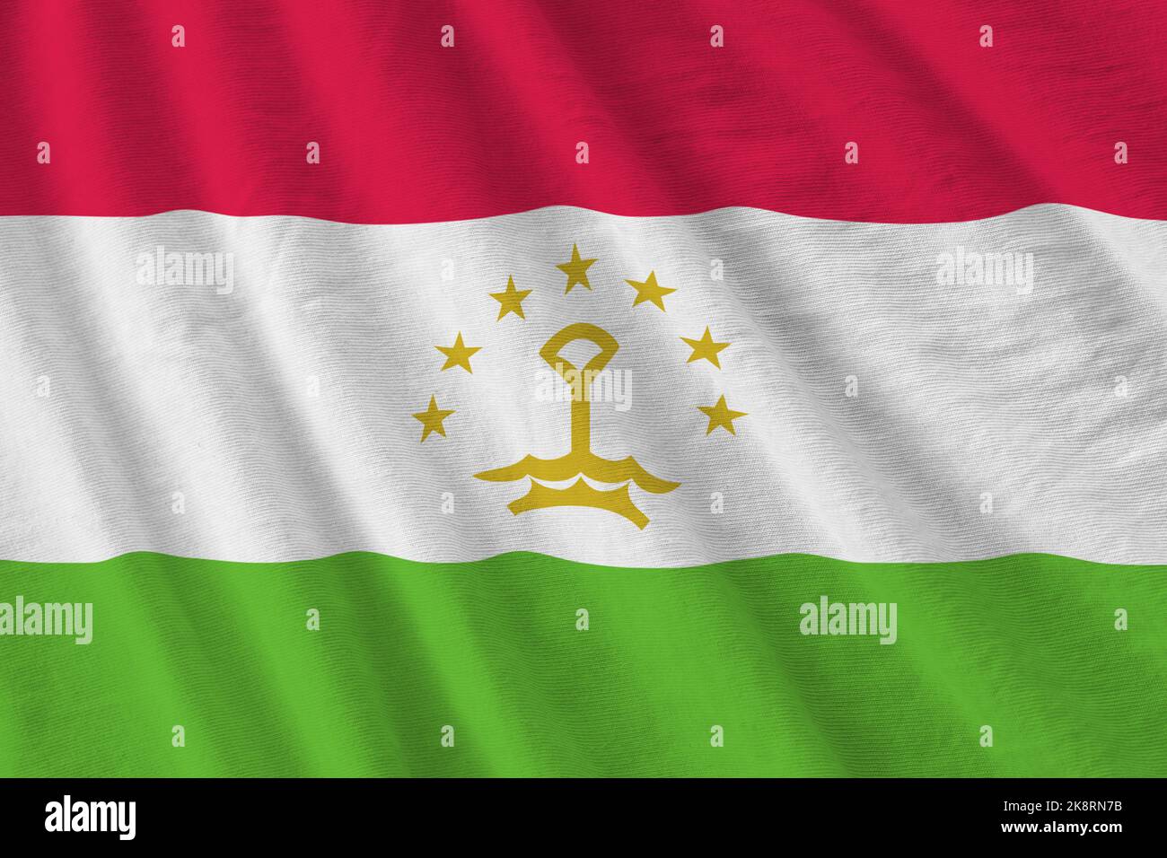 Tajikistan flag with big folds waving close up under the studio light ...
