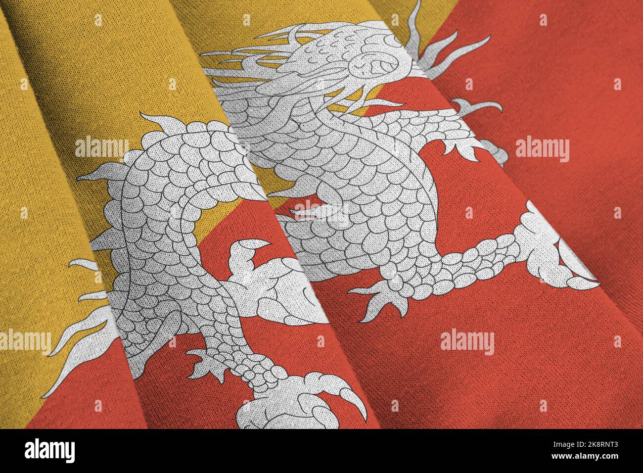 Bhutan flag with big folds waving close up under the studio light ...