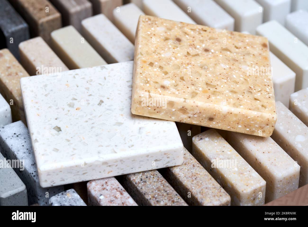 Porcelain two stoneware square samples laid on kitchen countertop ...