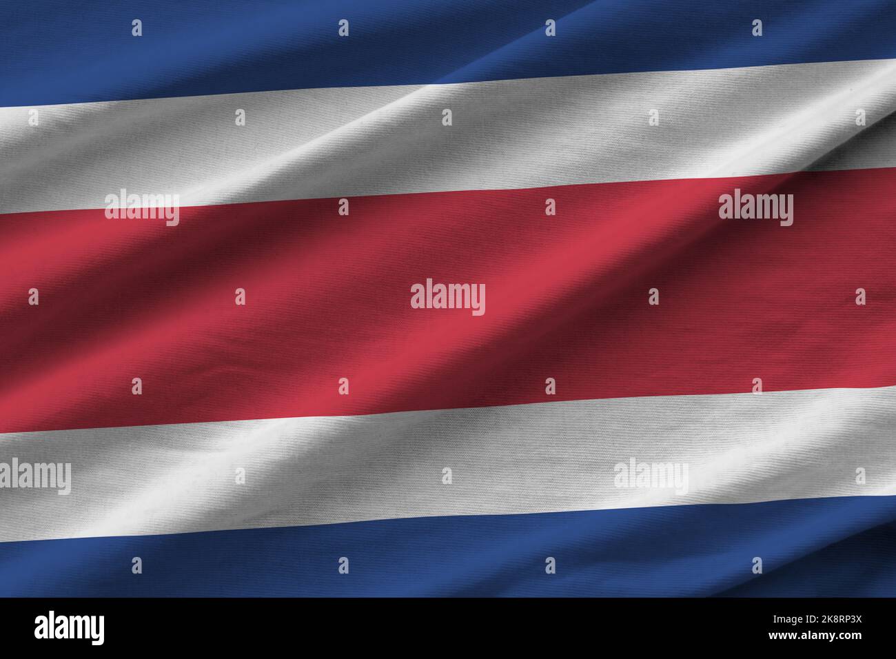 Costa Rica flag with big folds waving close up under the studio light ...