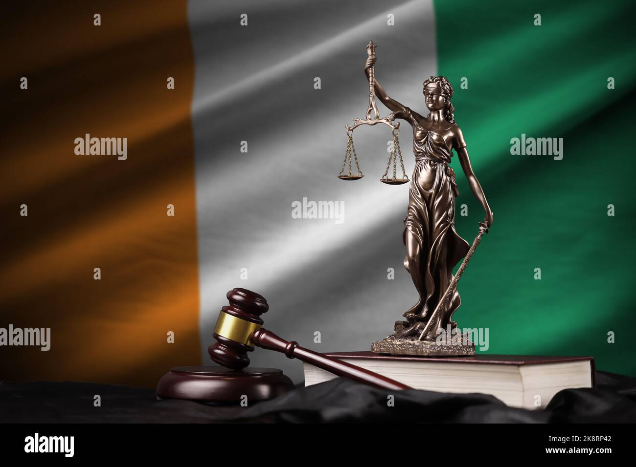 Ivory Coast flag with statue of lady justice, constitution and judge ...