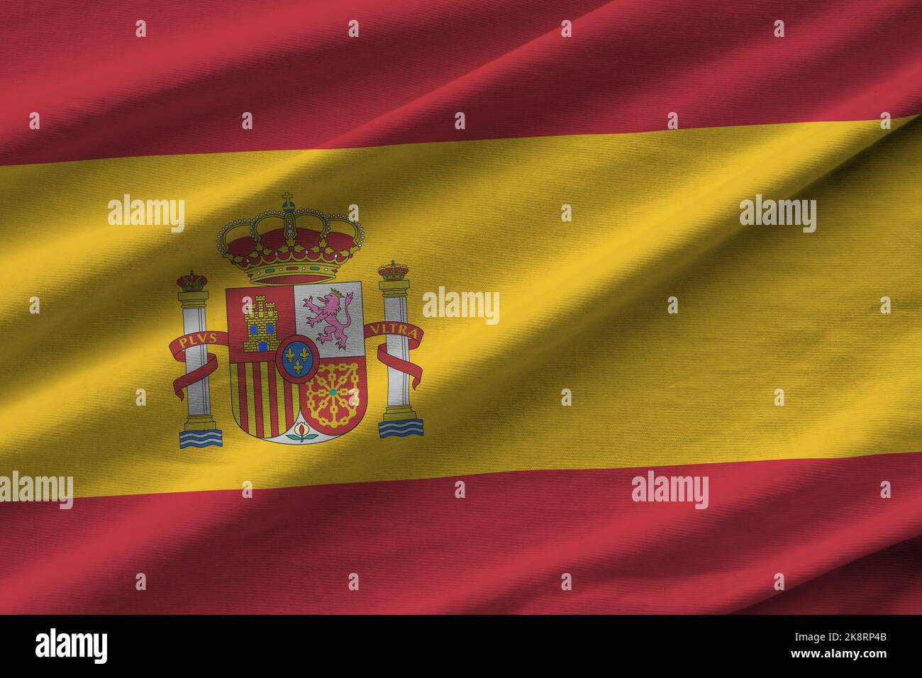 Spain flag with big folds waving close up under the studio light ...