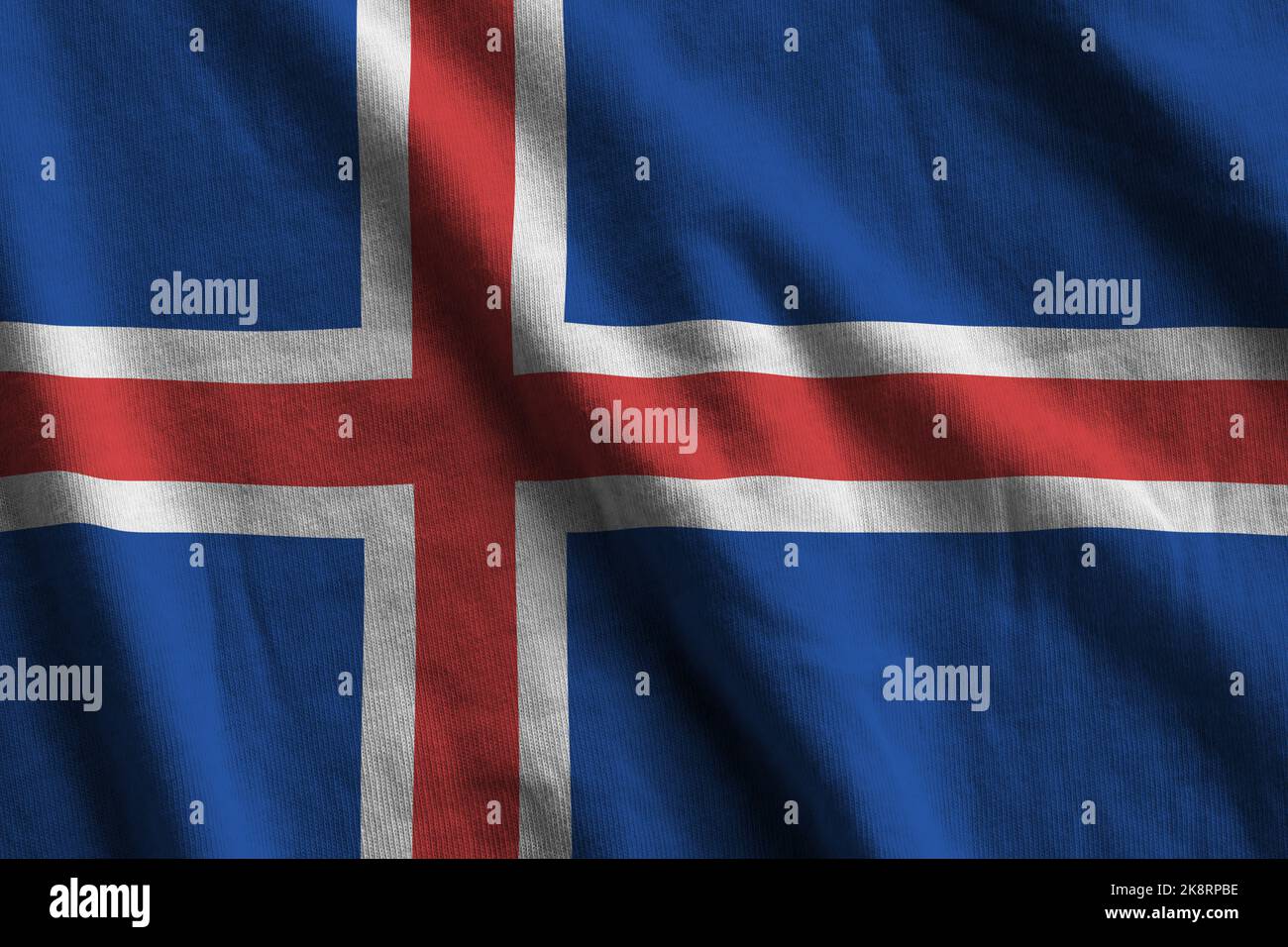 Iceland flag with big folds waving close up under the studio light ...