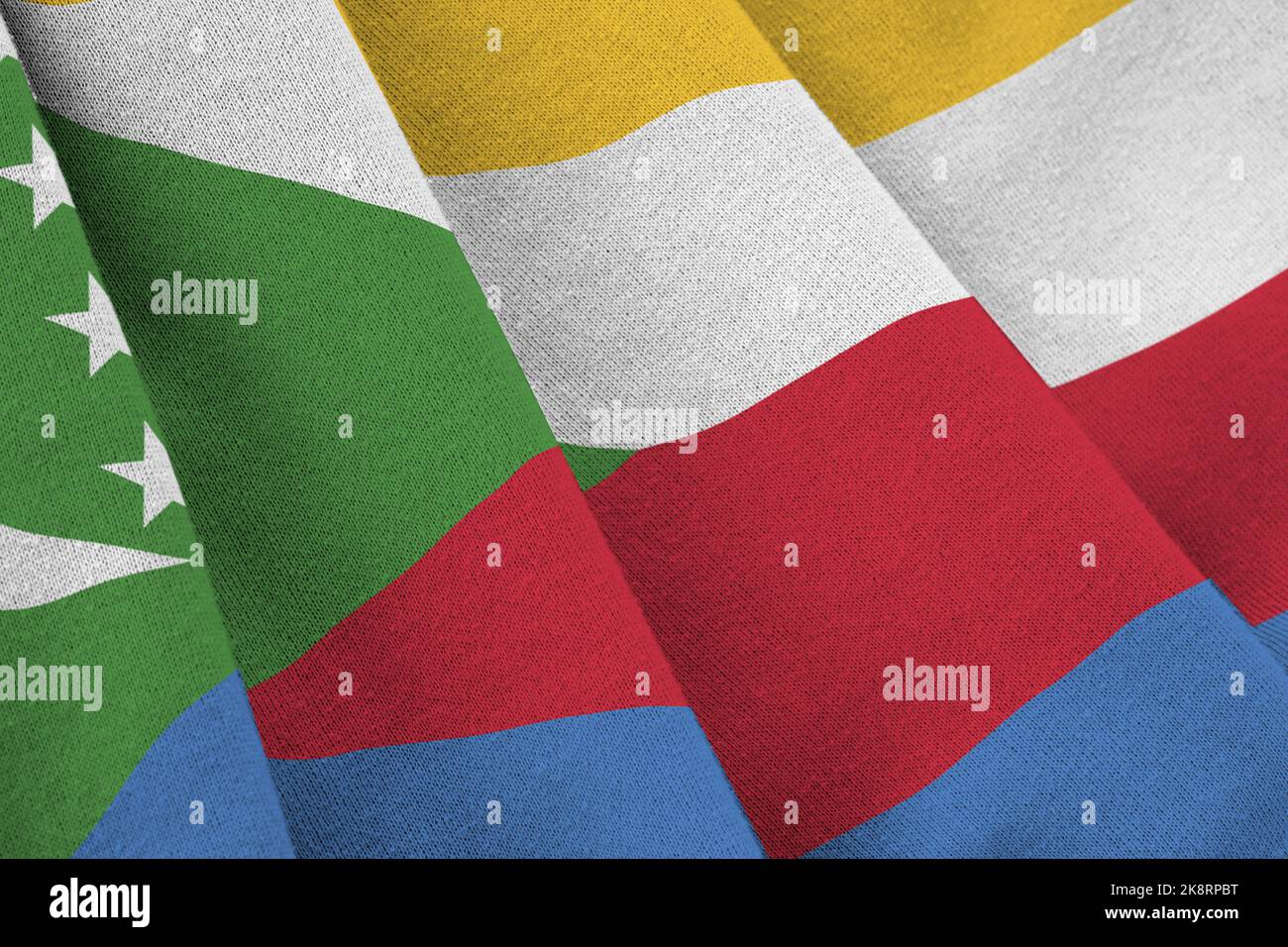 Comoros flag with big folds waving close up under the studio light ...