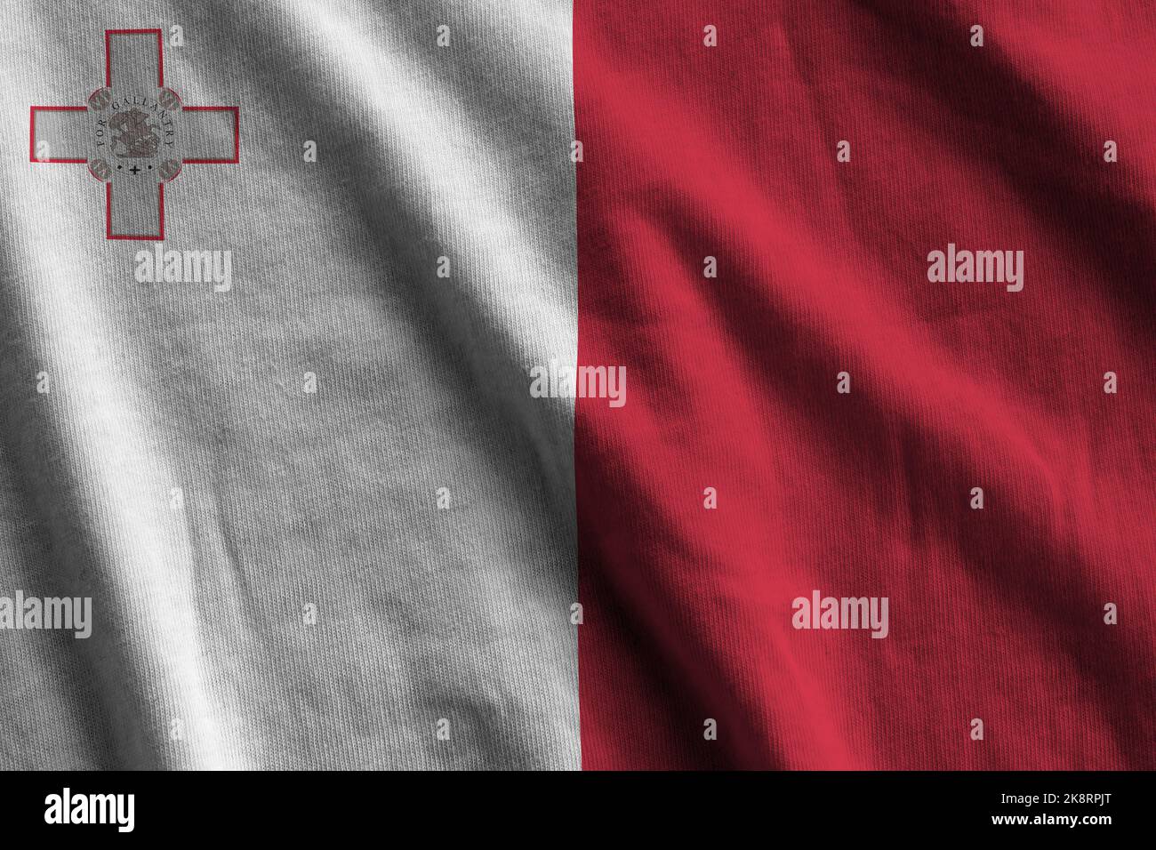Malta flag with big folds waving close up under the studio light ...