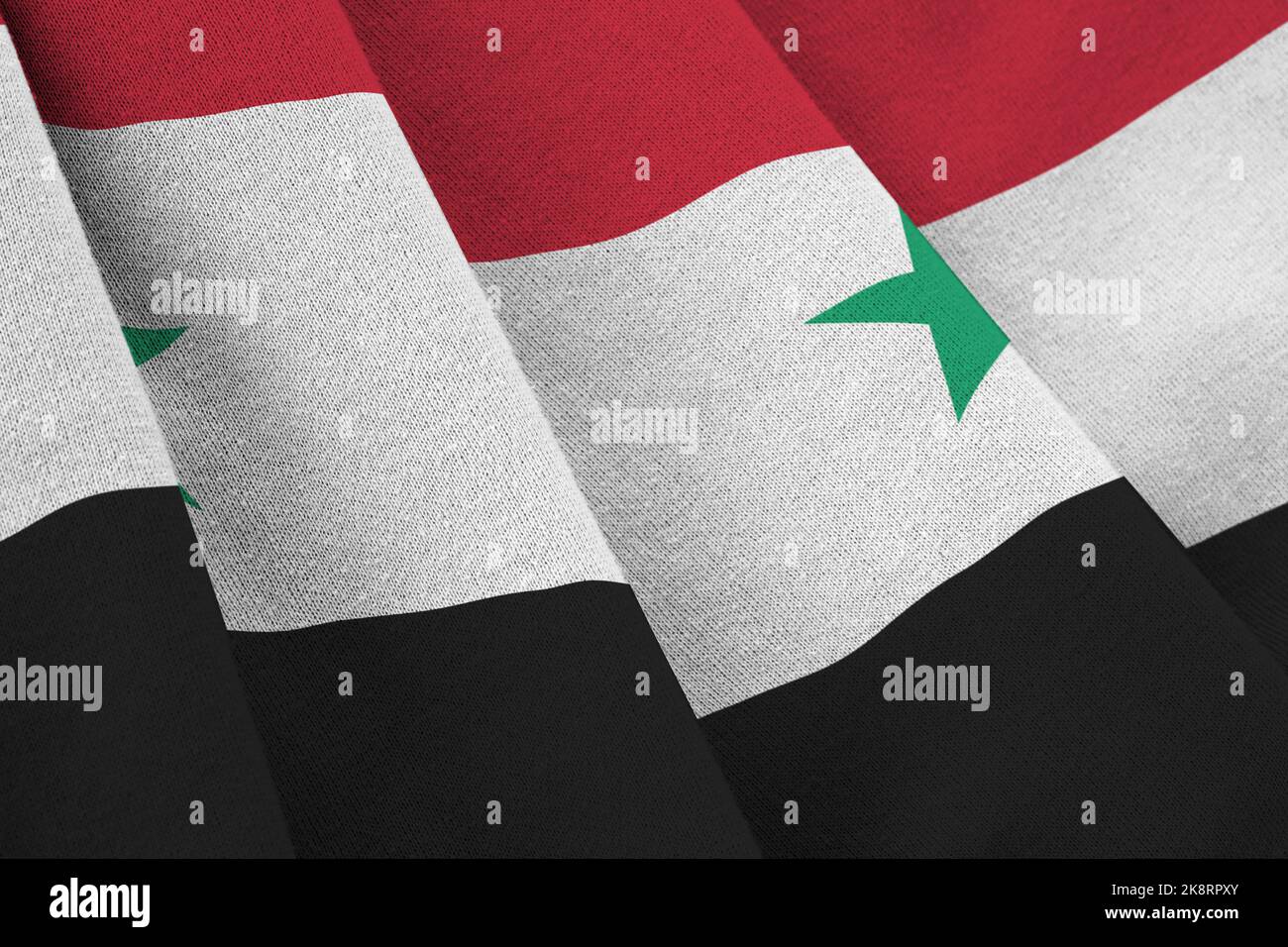 Syria flag with big folds waving close up under the studio light ...