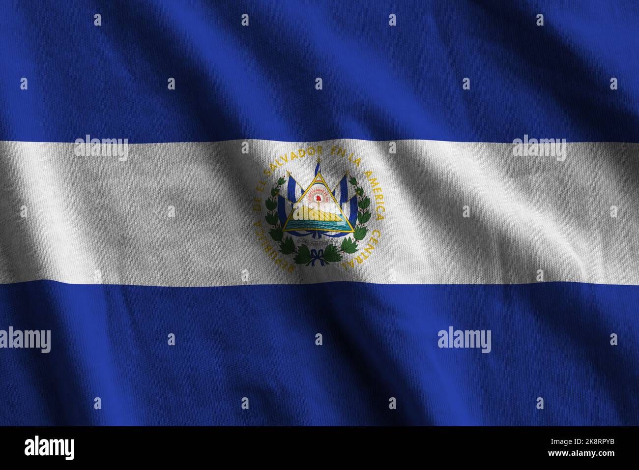 El Salvador flag with big folds waving close up under the studio light ...