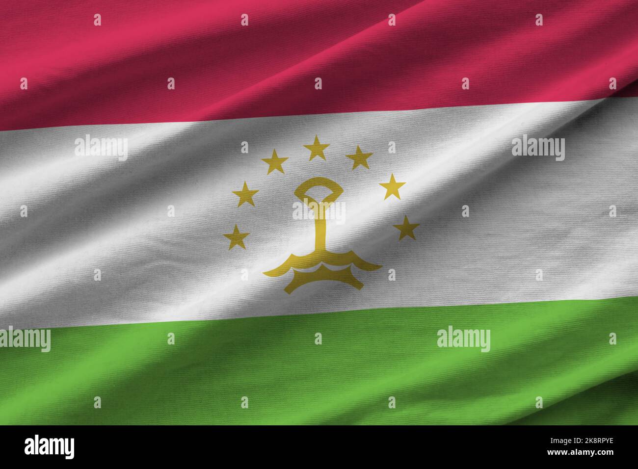 Tajikistan flag with big folds waving close up under the studio light ...