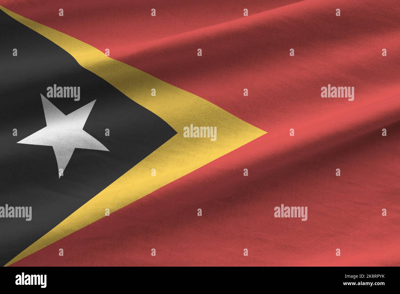 Timor Leste flag with big folds waving close up under the studio light ...